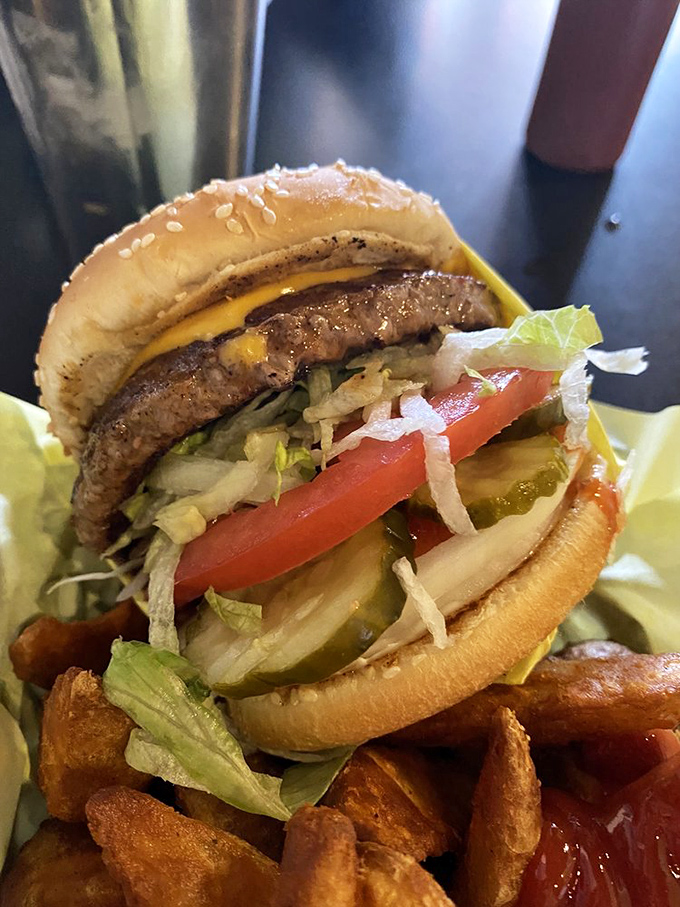 Now that's what I call a burger! Stacked high with fresh veggies, this beauty is a testament to the art of burger craftsmanship.