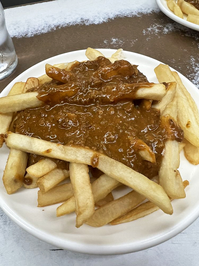 Chili-topped fries: where fork meets finger food. It's a delicious dilemma &ndash; dive in with utensils or embrace the mess?