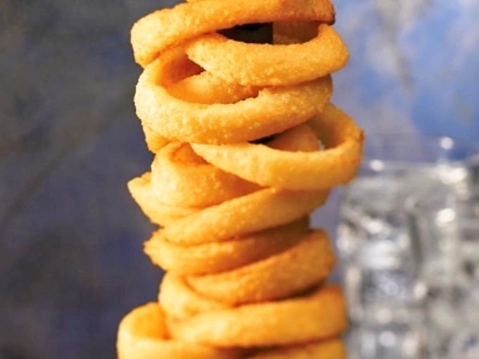 Behold, the leaning tower of onion rings! These golden hoops are stacked higher than your grandkid's Lego creations.