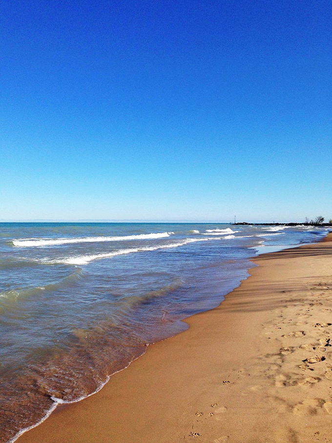 The lake's daily dance routine: gentle waves lapping at golden shores. It's like nature's own relaxation app, but way better.