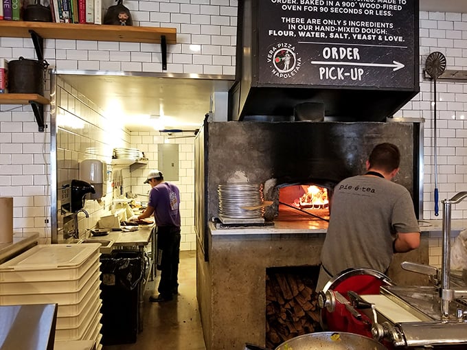 Pizza wizards at work! These folks are like the Hogwarts professors of dough, casting spells of deliciousness in that wood-fired oven.