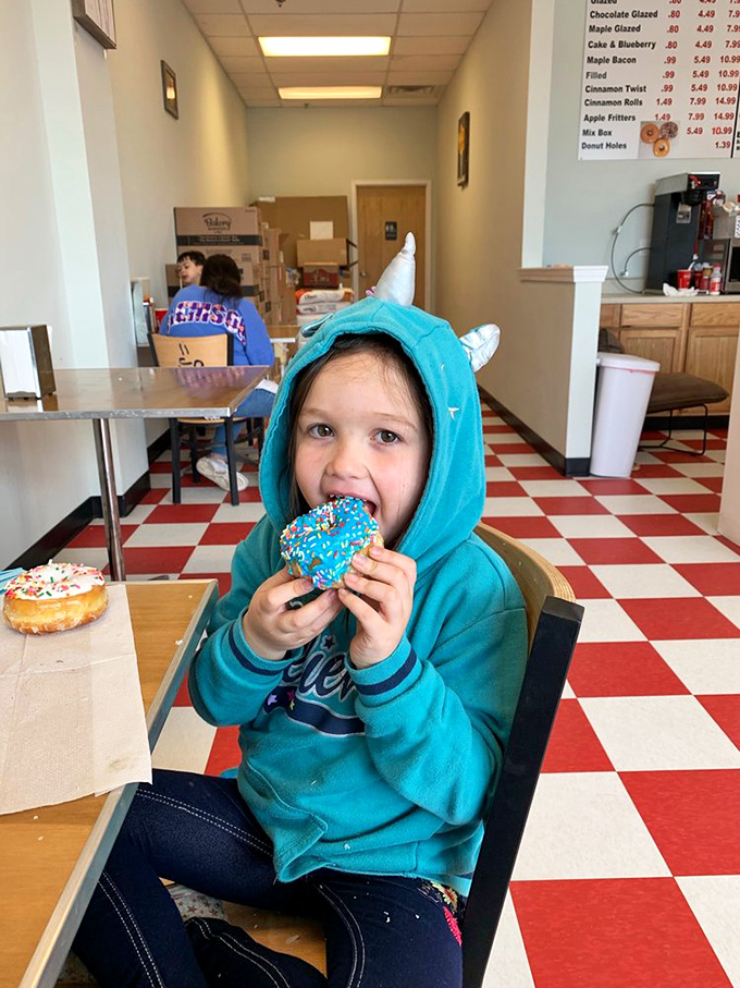 Happiness is a child with a donut! This young connoisseur knows that blue sprinkles are the key to a perfect day.