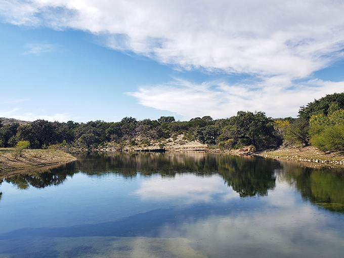 "Mother Nature's mirror for military might." The tranquil lake reflects the beauty of the Texas Hill Country, a serene contrast to the rumbling tanks.