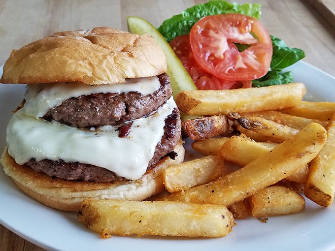 Burger bliss achieved! This juicy masterpiece, flanked by crispy fries, is the stuff of diner legends. No fancy frills, just pure satisfaction.