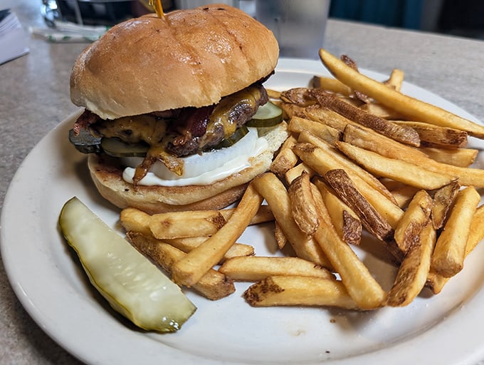 Burger bliss achieved! This juicy masterpiece, flanked by crispy fries and a pickle, is the stuff food dreams are made of.