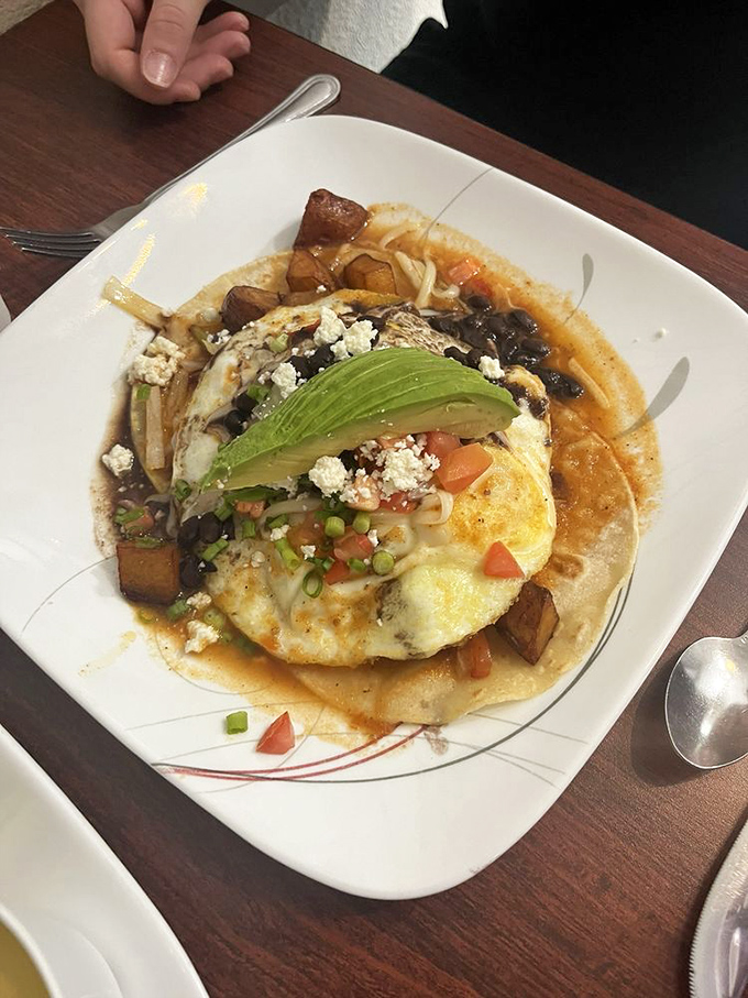 Huevos Rancheros: Where breakfast meets fiesta! This colorful plate is a flavor explosion waiting to happen, topped with a perfectly ripe avocado slice.