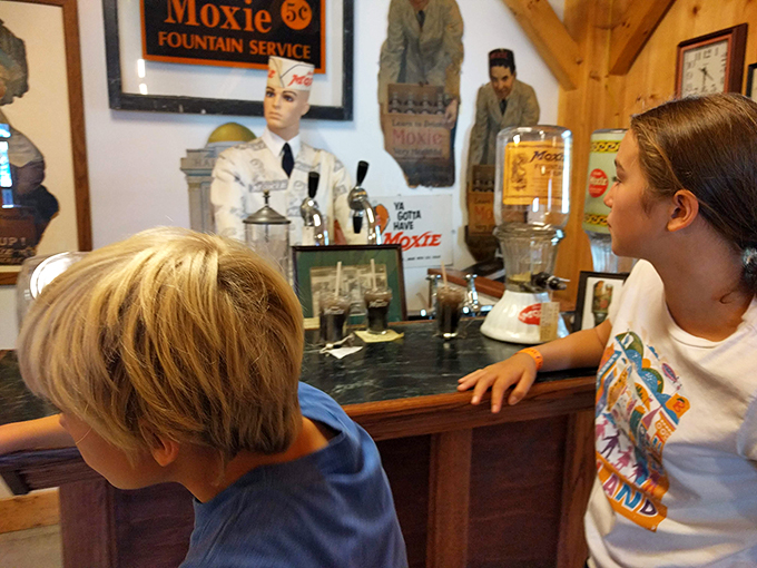 Mom, can we take this soda fountain home? Kids discovering the magic of vintage Moxie – it's like watching history come alive through tiny taste buds.