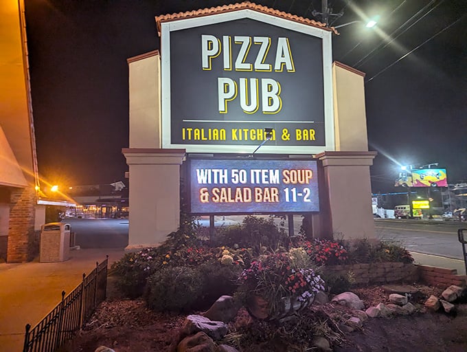The bat signal for pizza lovers! This illuminated sign is like a lighthouse, guiding hungry travelers to a safe harbor of deliciousness.