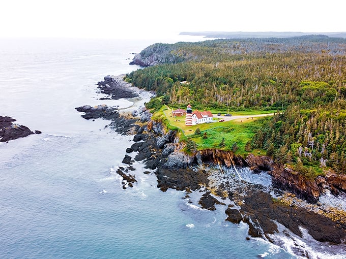 Bird's eye beauty! This aerial view showcases nature's masterpiece &ndash; a lighthouse perched on Maine's dramatic coastline.