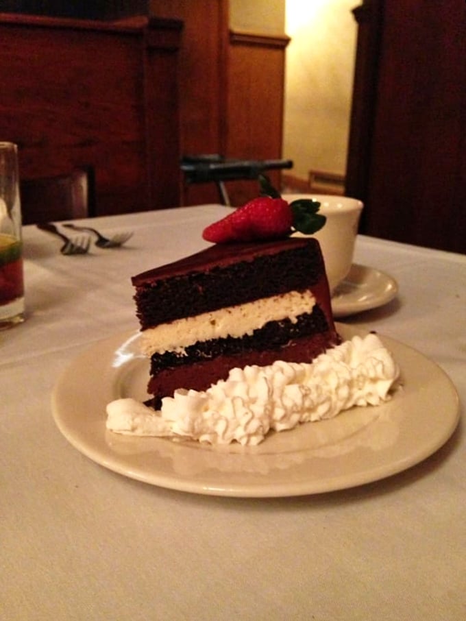 Layer upon layer of decadence! This towering slice of chocolate cake, crowned with a strawberry, is the stuff of sweet dreams. Dieters, avert your eyes!
