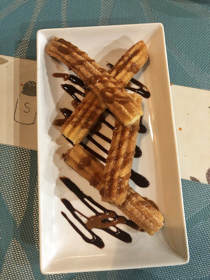 Churros: the dessert that thinks it's a hug. Drizzled with chocolate, these crispy delights are the perfect sweet ending to any meal at Rossy's.