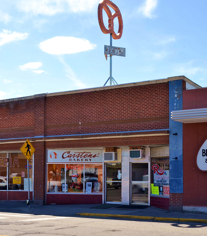 The beacon of baked goods! This exterior view, complete with that iconic pretzel sign, is basically a lighthouse guiding hungry souls to sugary salvation.