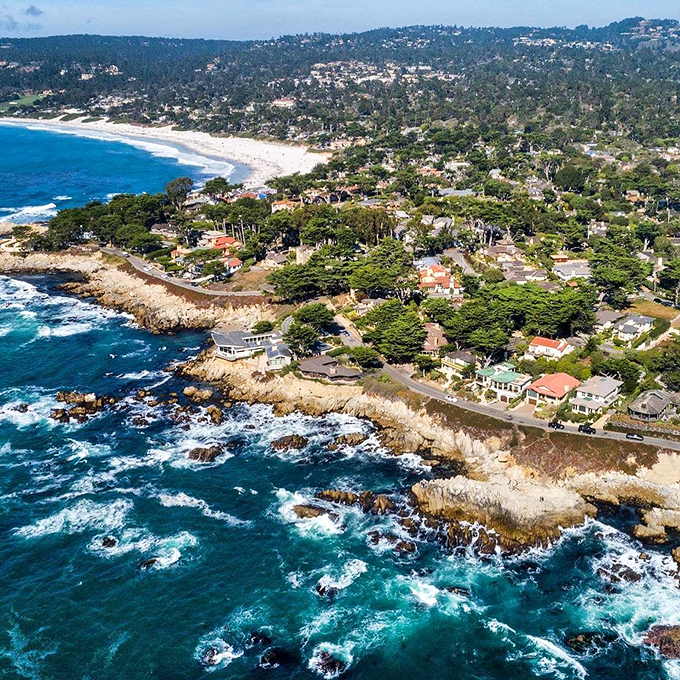 Carmel-by-the-Sea: Where fairytale cottages meet the sea. This aerial view showcases the town's charming blend of European-style architecture and stunning coastline.