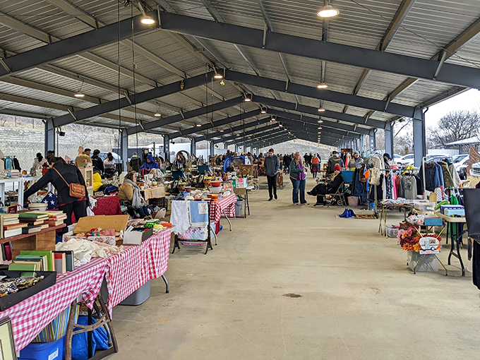Bargain hunters navigate the covered pavilions of Nashville Flea Market, where red-checkered tablecloths stretch endlessly like a picnic gone wonderfully wild.