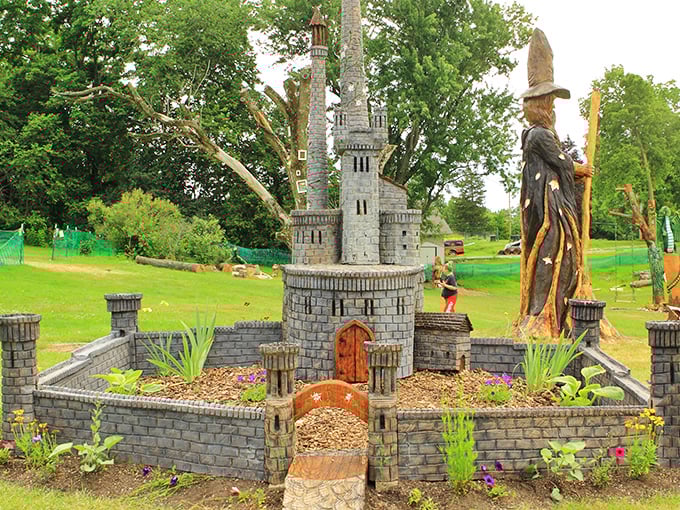 Medieval meets whimsy! A towering wooden wizard and pint-sized castle transform this garden into a storybook come alive.