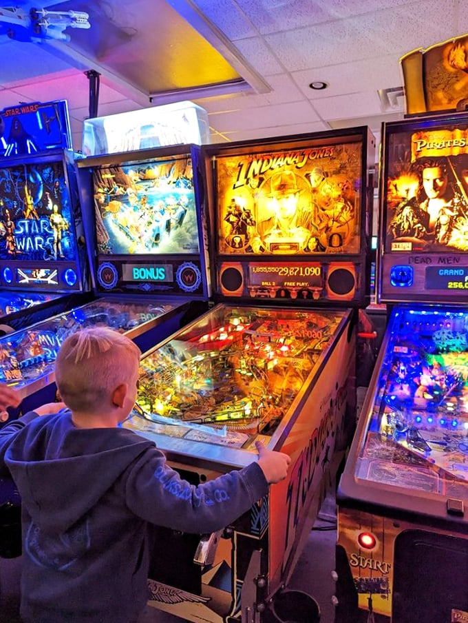 Witness the torch of gaming passion being passed down. This little maestro's already mastering the flipper dance &ndash; future pinball wizard in the making!