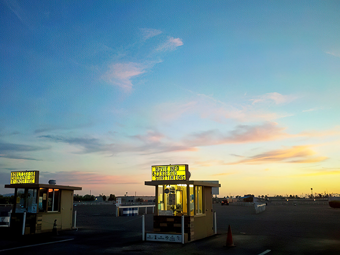 Showtime approaches as the sky puts on its own spectacle. The ticket booths glow with anticipation, ready to usher in a night of movie magic.