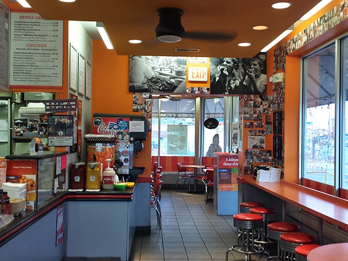Step into a time machine of taste! This retro-chic interior, with its vibrant orange walls and nostalgic decor, sets the stage for a culinary adventure that's pure Americana.