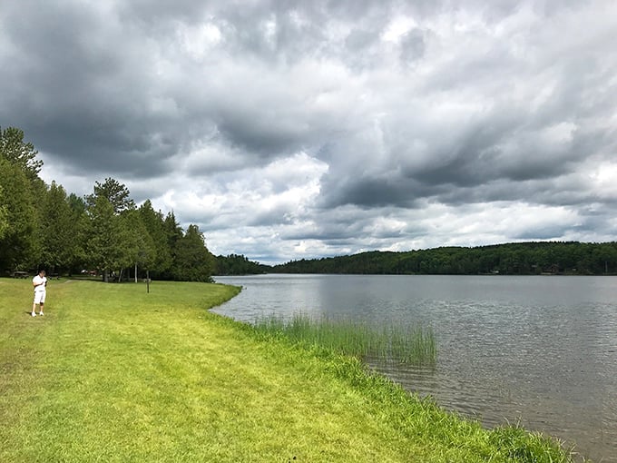 Serenity now! This lakeside scene is so peaceful, it could make a New York cabbie whisper. Tranquil waters mirror the sky, inviting quiet contemplation.
