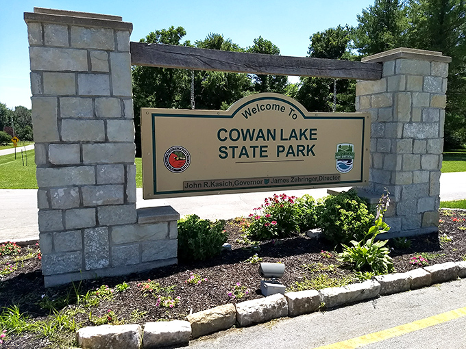 Welcome to paradise! This stone sentinel stands guard, inviting weary travelers to leave their worries at the gate. It's like the pearly gates, but with more picnic tables.