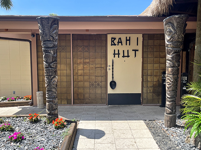Tiki totems stand guard at Bahi Hut, like wooden bouncers protecting a portal to 1954. Time travel never looked so inviting!