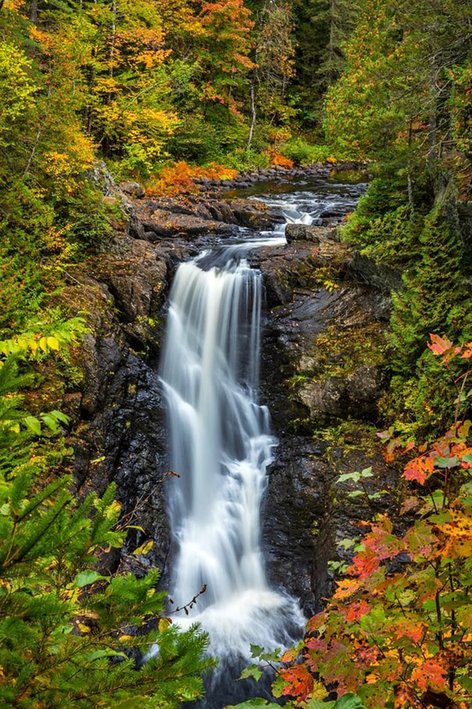 Nature's own light show! Moxie Falls puts on a dazzling display, framed by autumn foliage that'd make a leaf peeper weep with joy.