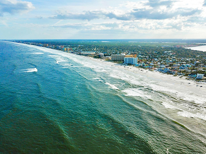 New Smyrna Beach: Where the ocean meets civilization. This bird's-eye view showcases the perfect blend of urban amenities and natural beauty.