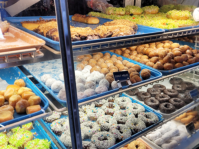 Behold the Sistine Chapel of fried dough! This display case is a masterpiece of sugary temptation that would make even the Mona Lisa smile.