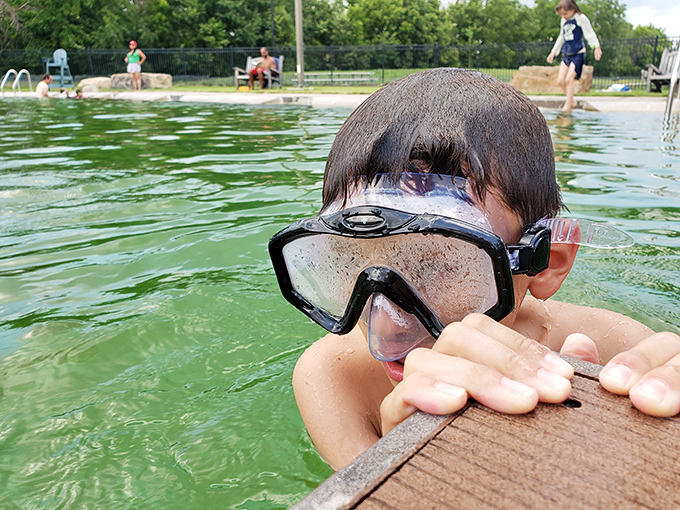 Dive into childhood joy! This young explorer's goggle-clad enthusiasm perfectly captures the simple pleasures of a summer swim. Marco Polo, anyone?
