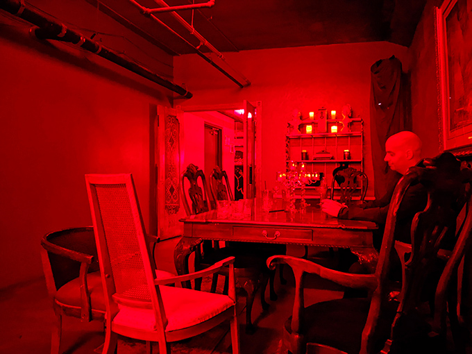Bathed in red light, this cozy nook whispers of secrets shared and friendships forged over perfectly mixed drinks.