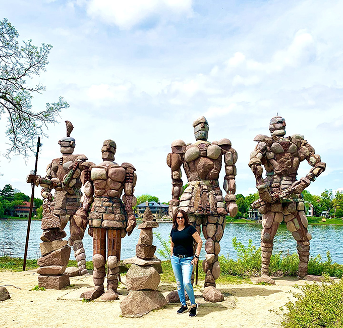 "Size matters! A visitor provides scale, proving these rock stars aren't just boulders with delusions of grandeur."