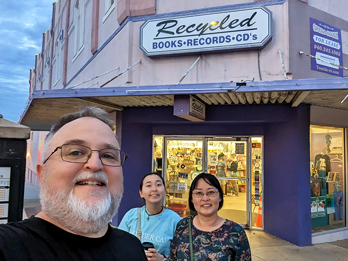Bookworms unite! Happy customers pose outside, their smiles as bright as the store's vibrant exterior. It's like Disneyland for the literati!