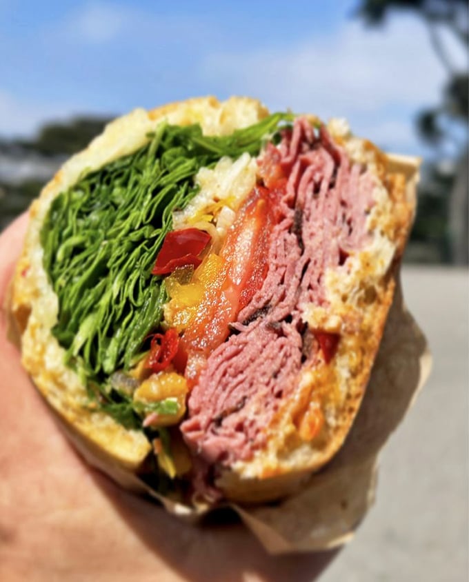 Holy moly, that's a sandwich! Layers of pastrami, veggies, and who-knows-what-else create a towering masterpiece that'd make Dagwood Bumstead jealous.