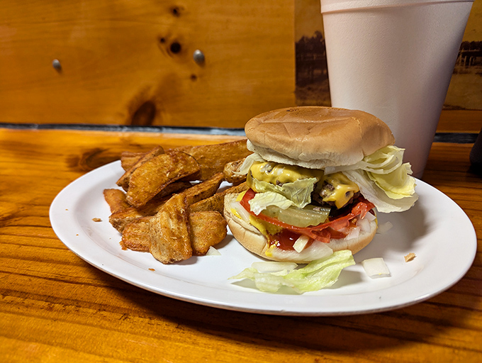 Burger bliss achieved! This juicy masterpiece, flanked by golden potato wedges, is what food dreams are made of.