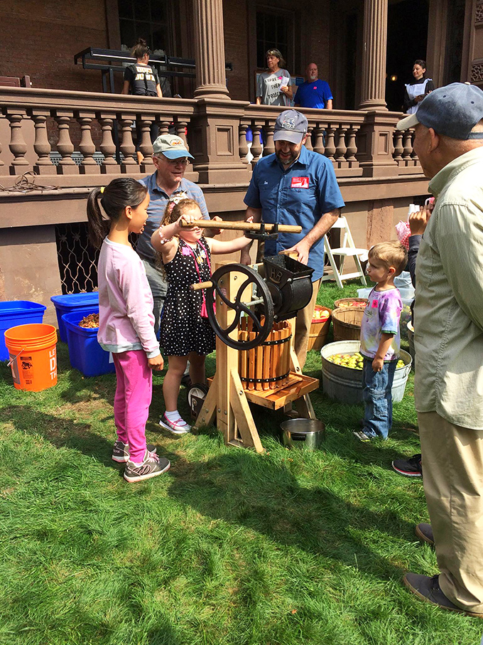 Step right up, folks! It's not every day you get to churn butter like it's 1859. These visitors are getting a taste of ye olde Maine life.