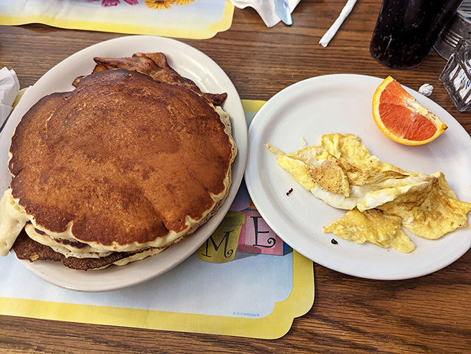 Holy flapjacks, Batman! This pancake is so big it needs its own area code. And those eggs? They're sunny side up and ready to party.