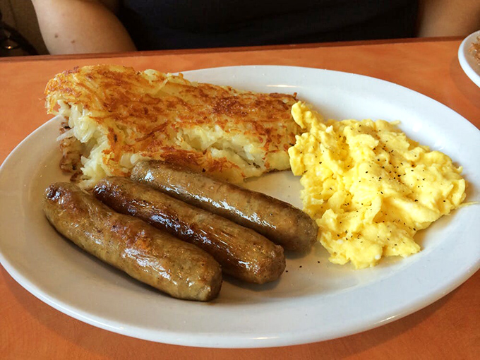 The breakfast trifecta: crispy hash browns, plump sausages, and eggs so fluffy they could float away. It's the holy trinity of morning indulgence.