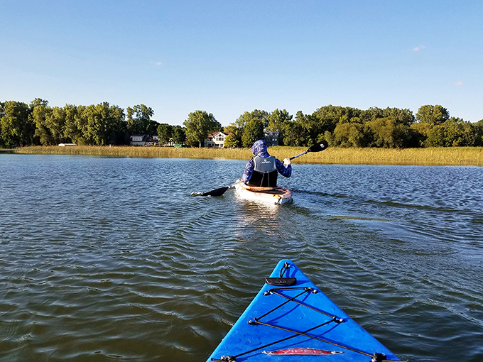 Paddle your way to serenity! This kayaking scene is more soothing than a Bob Ross painting marathon.