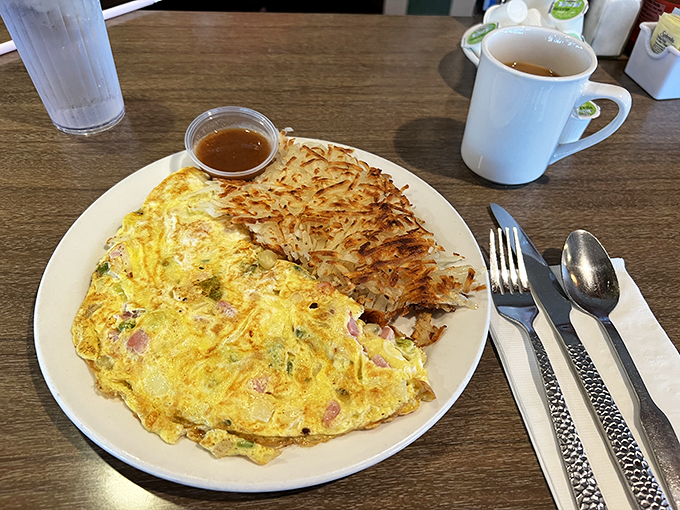 Omelettes so big, they have their own zip code! Paired with hash browns crispier than your grandpa's jokes, this plate is a morning feast fit for a king &ndash; or a very hungry commoner.