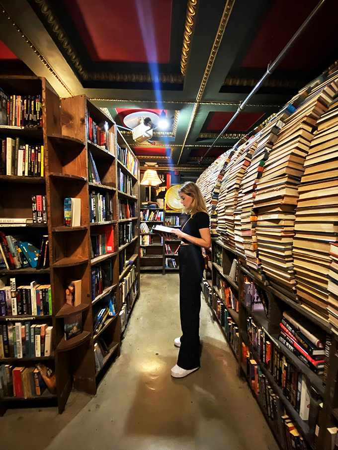 Lost in a good book or lost in the store? This reader seems to have found her happy place among the towering shelves of literary treasures.