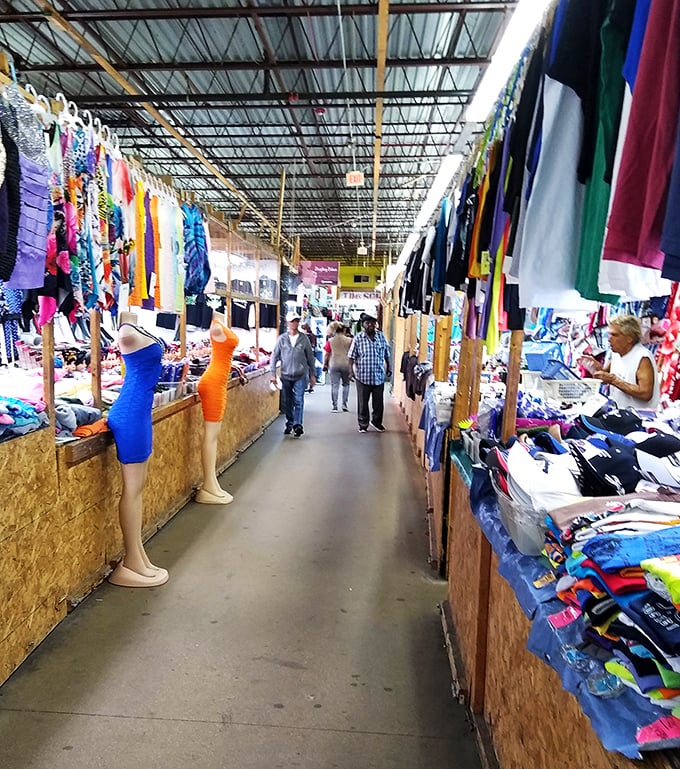 Bargain hunting in style! These savvy shoppers navigate a colorful corridor of clothing, proving that one man's fashion faux pas is another's vintage victory.