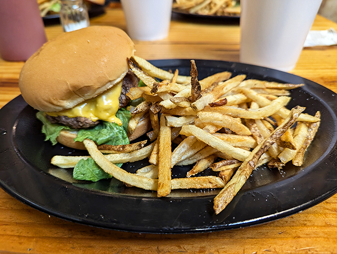 Behold, the holy trinity of diner fare! A perfectly stacked cheeseburger, crispy fries, and an ice-cold drink – name a more iconic trio.