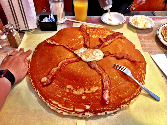 Holy flapjacks, Batman! This pancake is so enormous, it could double as a delicious life raft. Syrup sold separately, bring your own paddle.