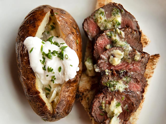 A baked potato so fluffy, it could double as a pillow. Paired with a perfectly seared steak, it's comfort food that gives you a warm hug from the inside.
