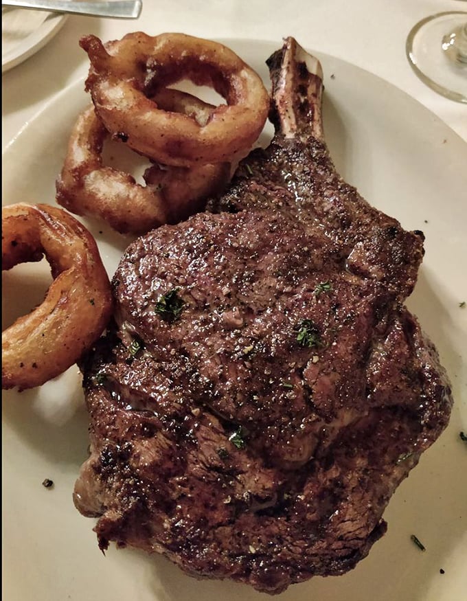 Holy cow! This bone-in ribeye, flanked by golden onion rings, is so massive it could double as a caveman's club. Fred Flintstone would approve.