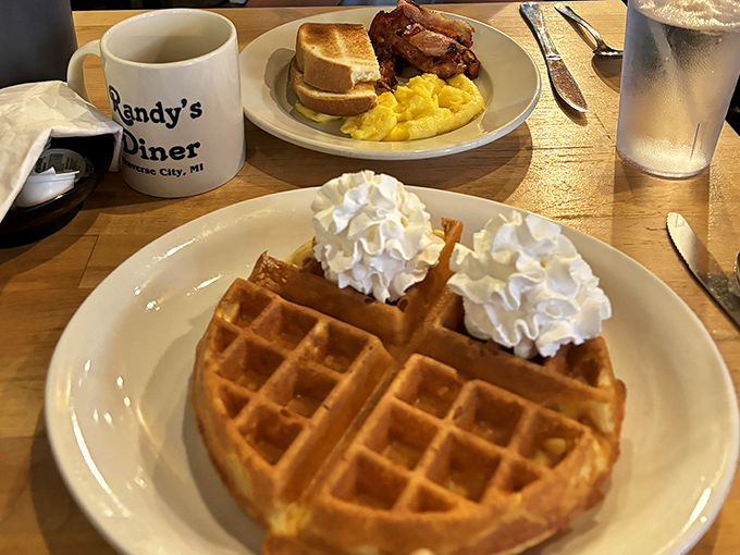 Waffle wonderland! This golden disc of deliciousness, crowned with whipped cream, is like a breakfast throne fit for the King of Morning himself.