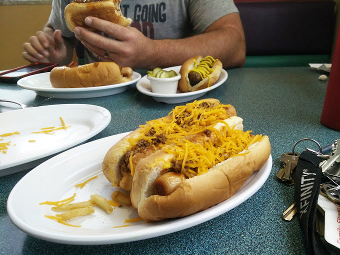 Chili overload in the best way possible! This double dog delight is like winning the lottery of lunch &ndash; messy, magnificent, and utterly irresistible.