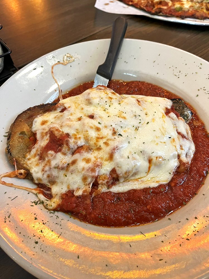 Eggplant Parmigiana: Where vegetables go to fulfill their cheesy dreams. It's like a warm hug for your taste buds, minus the awkward small talk.