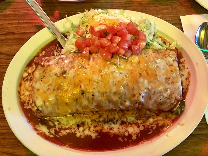 The burrito that thinks it's an enchilada! This plate is like a delicious identity crisis, topped with enough cheese to make Wisconsin jealous.