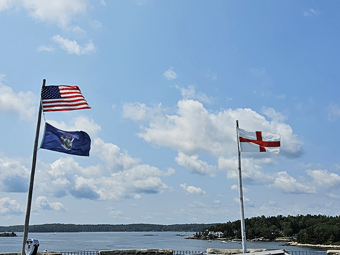 A trio of flags dance in the breeze, telling tales of allegiances past and present. History lesson with a side of patriotic flair!
